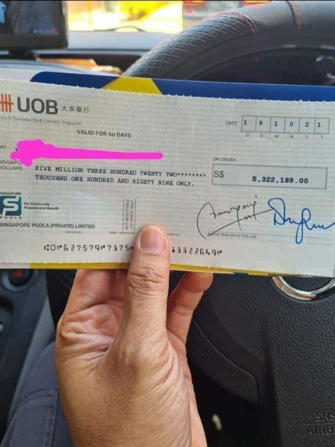 ONE OF THE WINNERS WHO WON TOTO $5M SHOWS HIS CHEQUE