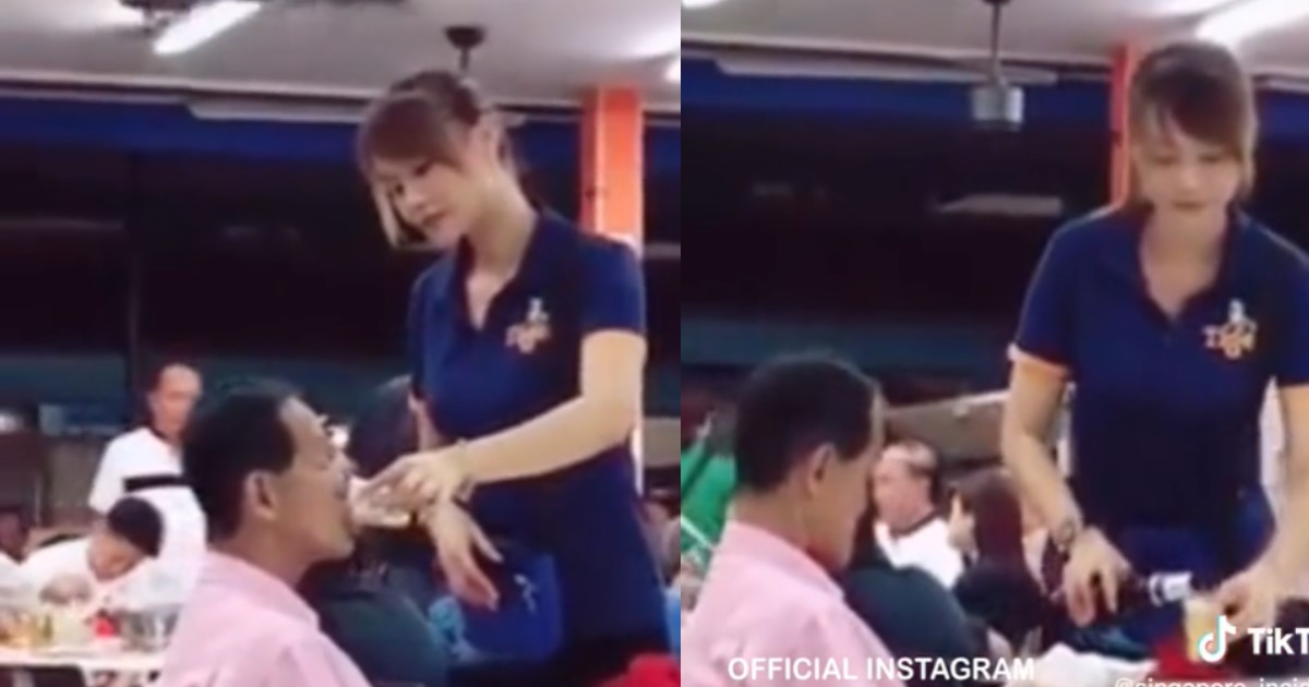 TIGER BEER PROMOTER GIRL HAND FEEDS UNCLE HIS BEER AT A COFFEESHOP